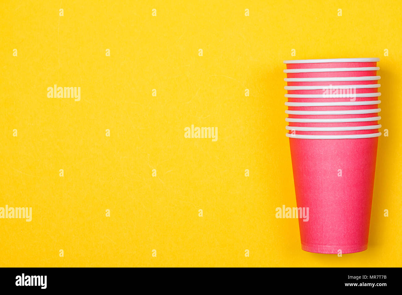Stacks of pink paper cups on yellow background Stock Photo - Alamy
