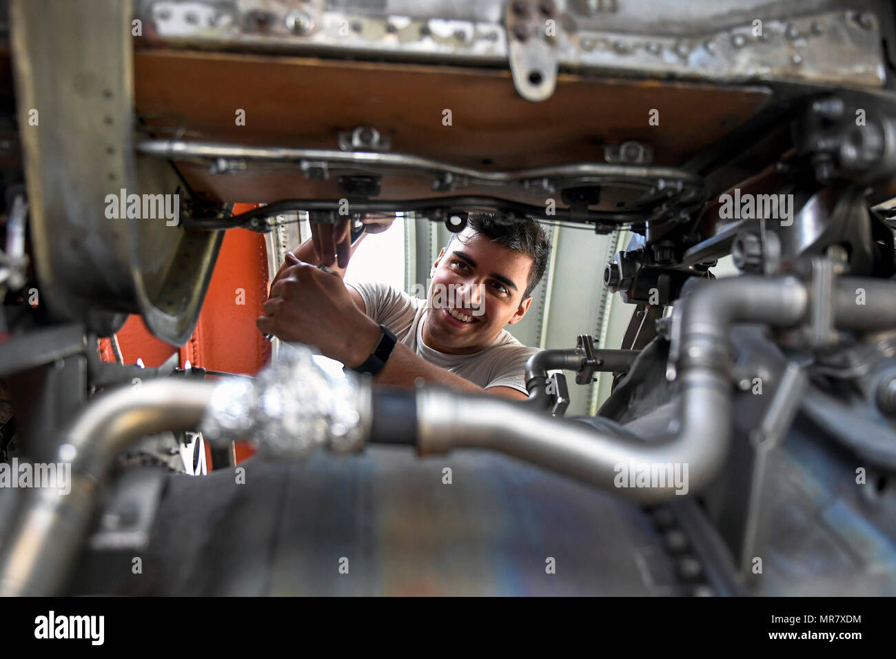 Senior Airman Eric Margoto performs maintenance on the tail engine of a ...