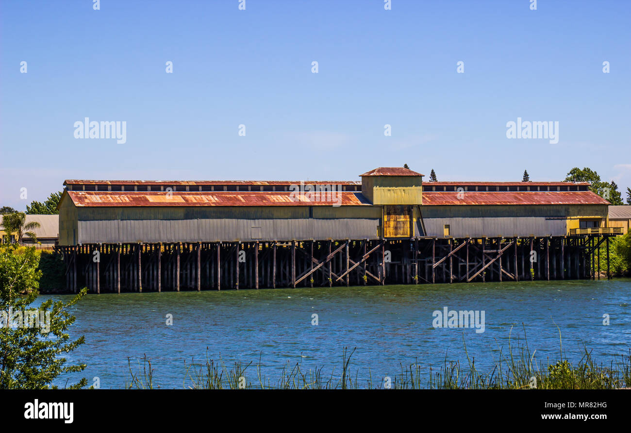 Vintage Rusty Metal Building On River Stock Photo - Alamy