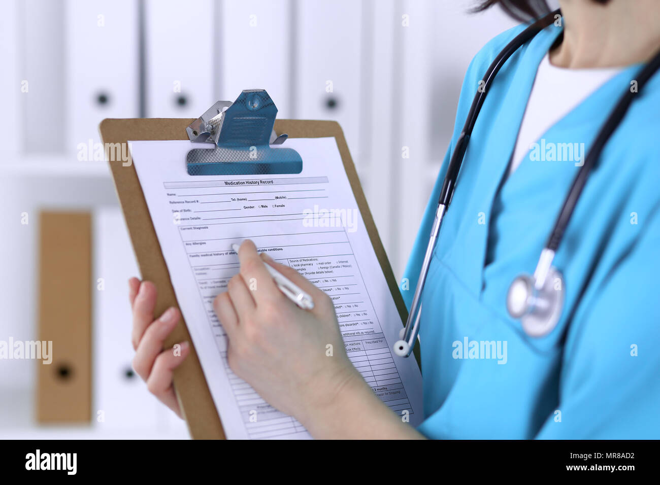 Female doctor filling up medical form on clipboard closeup. Physician ...
