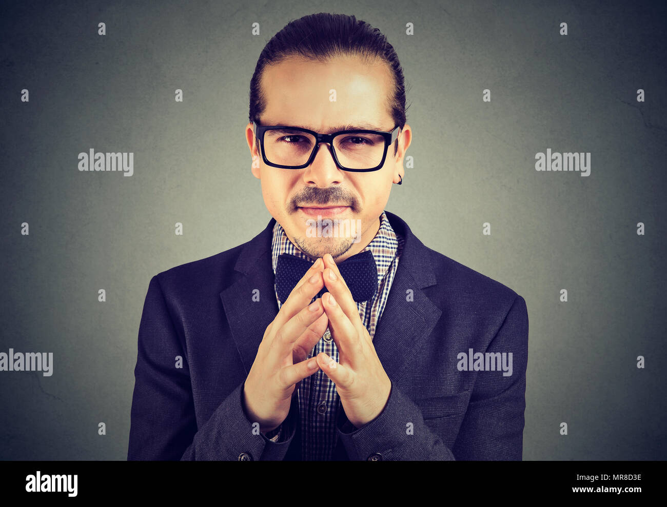 Sly business man in glasses looking at camera plotting a revenge Stock ...