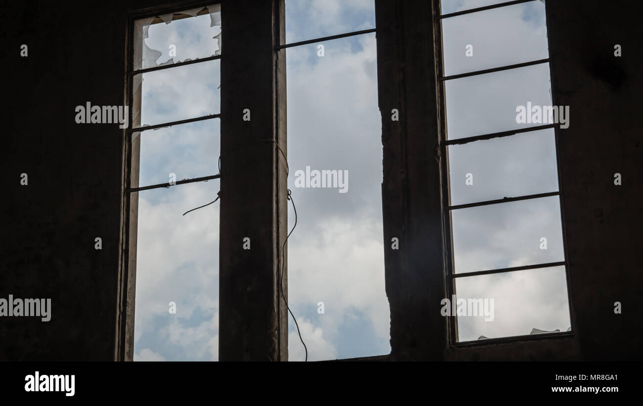 Broken window in an abandoned building - View from inside - sky with ...