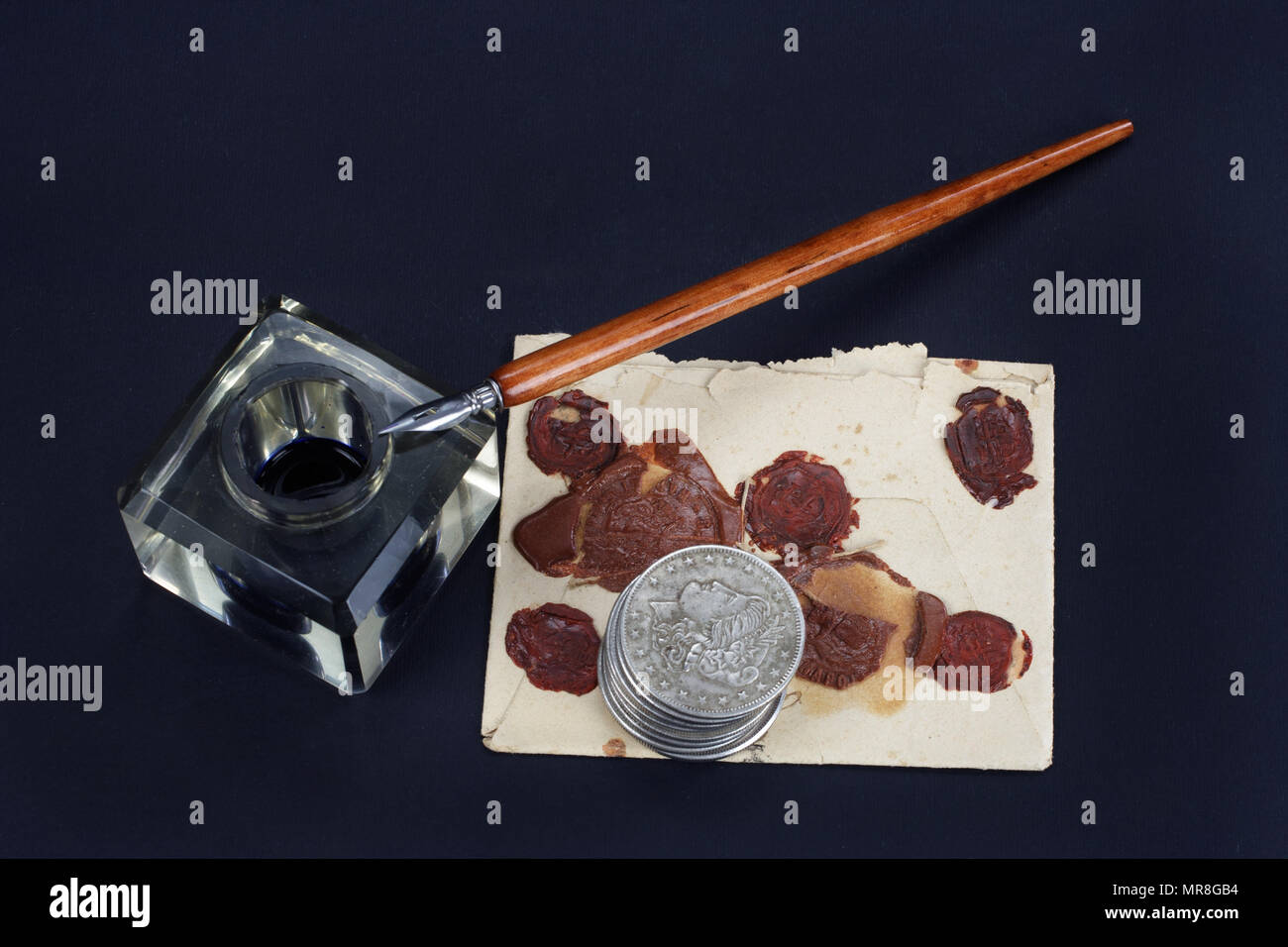 Old fountain pen and inkwell with old letters on a black textured ...