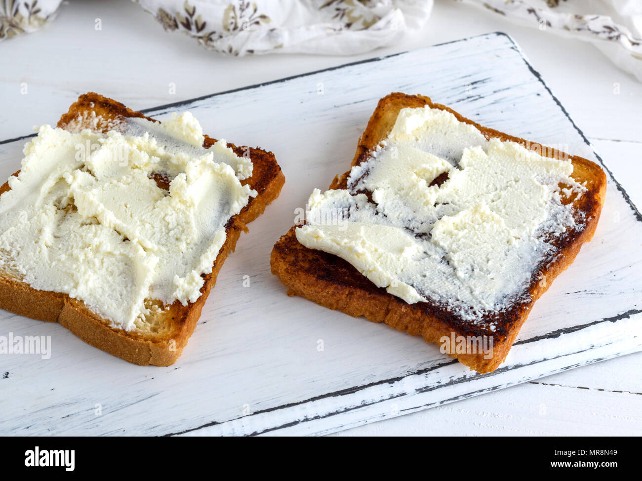 toasted bread with soft curd on a white wooden board, top view Stock ...