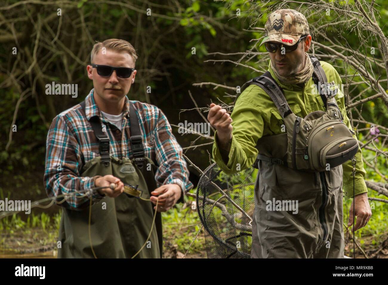 A fisherman teaches Cpl. Dustin Sexton, a field artillery cannoneer ...