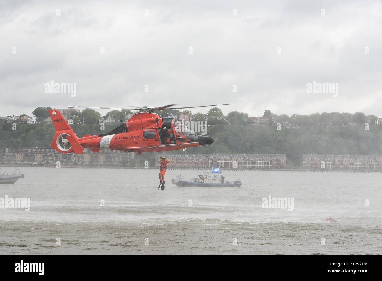 An HH-65 Dolphin helicopter hoists a rescue swimmer during a search and ...