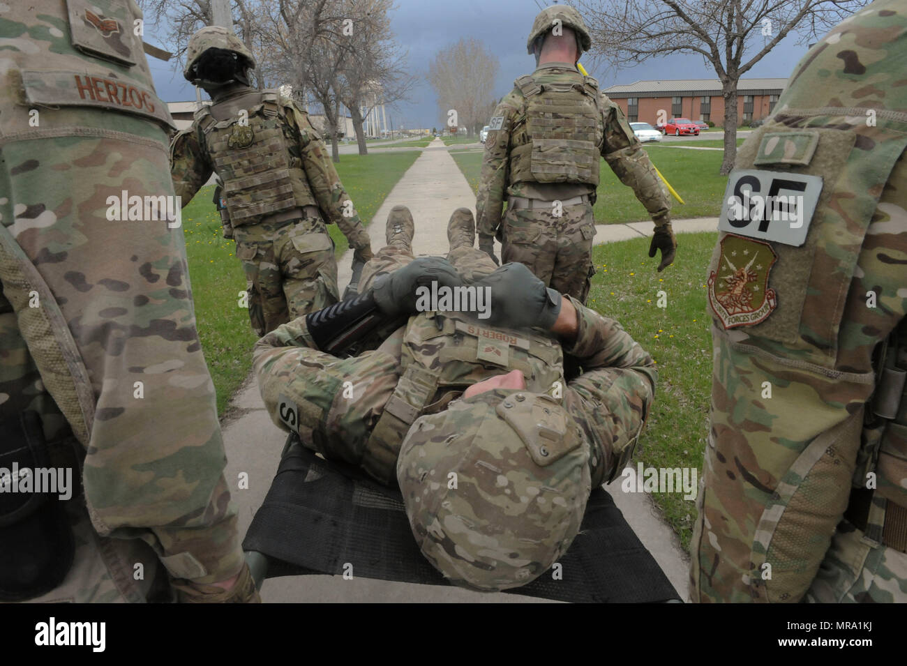 Members of the 91st Security Forces Group Global Strike Challenge team litter-carry a teammate ...