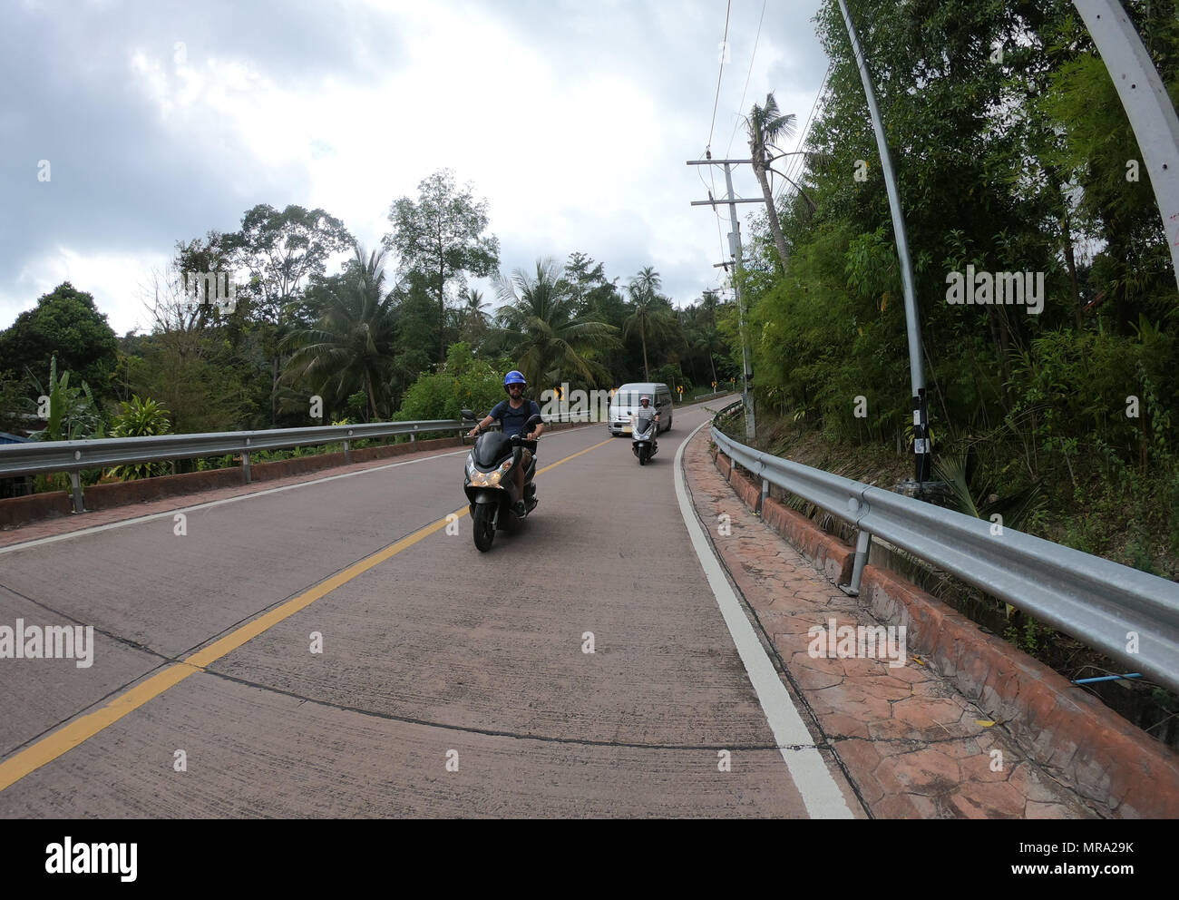 Man drive bike scooter on the road with palms in Thailand Stock Photo ...