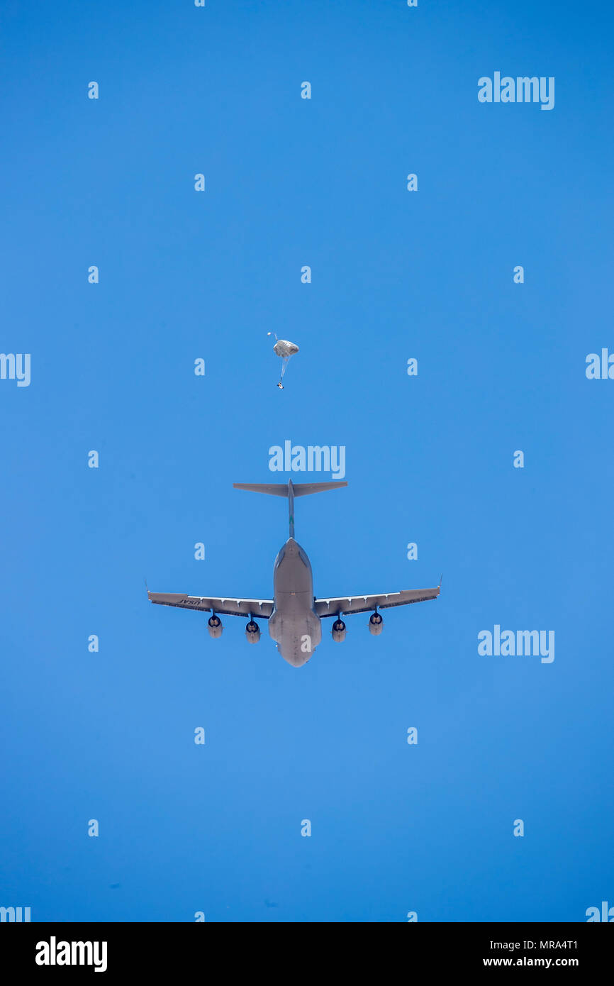 A parachute test dummy exits a C-17 Globemaster III and begins its ...