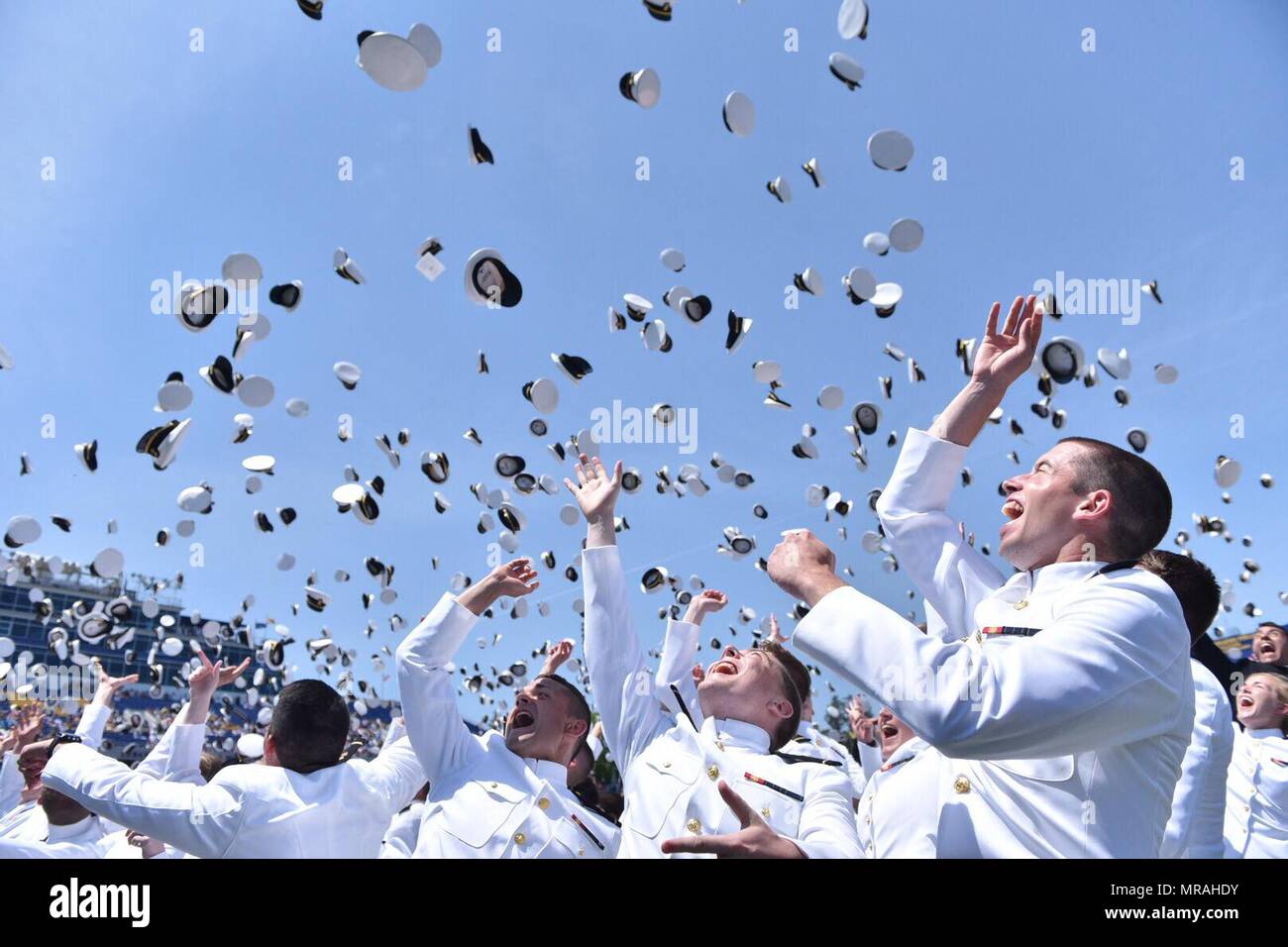 U.S. Naval Academy graduates toss their hats into the air during the ...