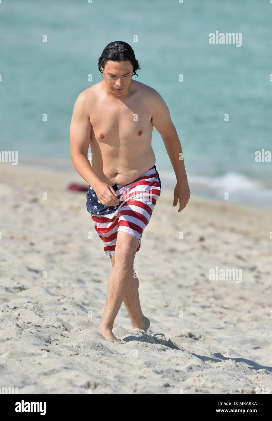 MIAMI BEACH, FL - MAY 14: Actor Jon Bass goes for a swim wearing ...
