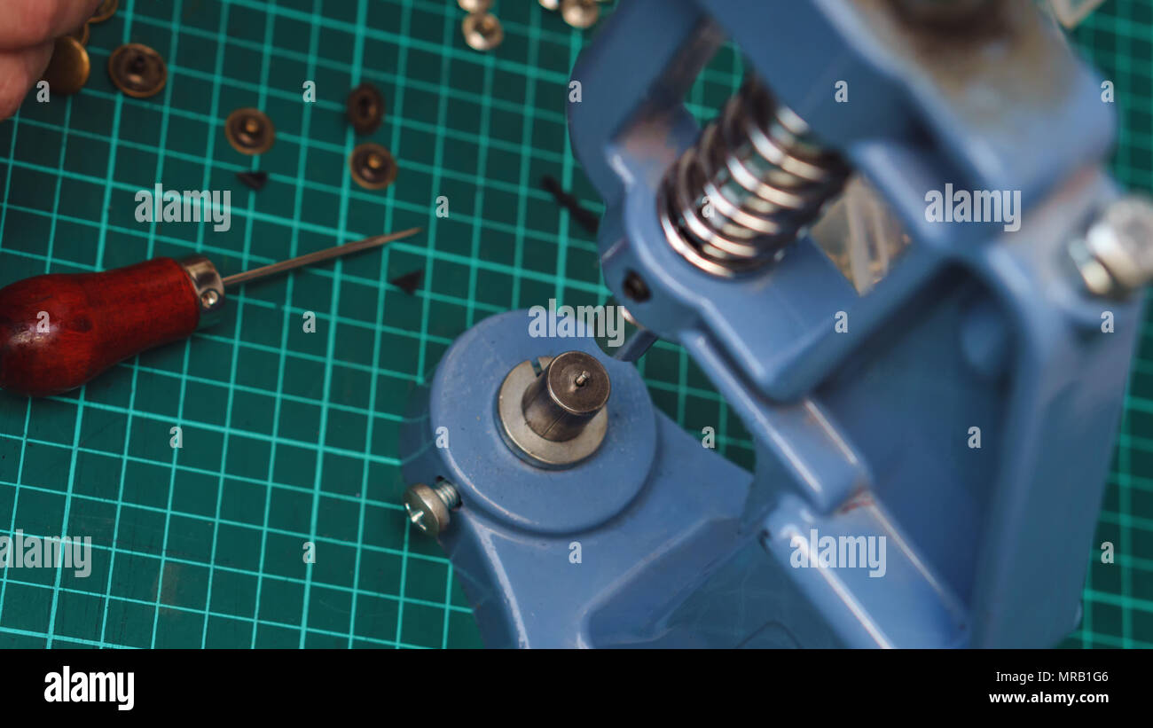Tools of the tanner. Riveter, awl rivets and fasteners are on the table ...