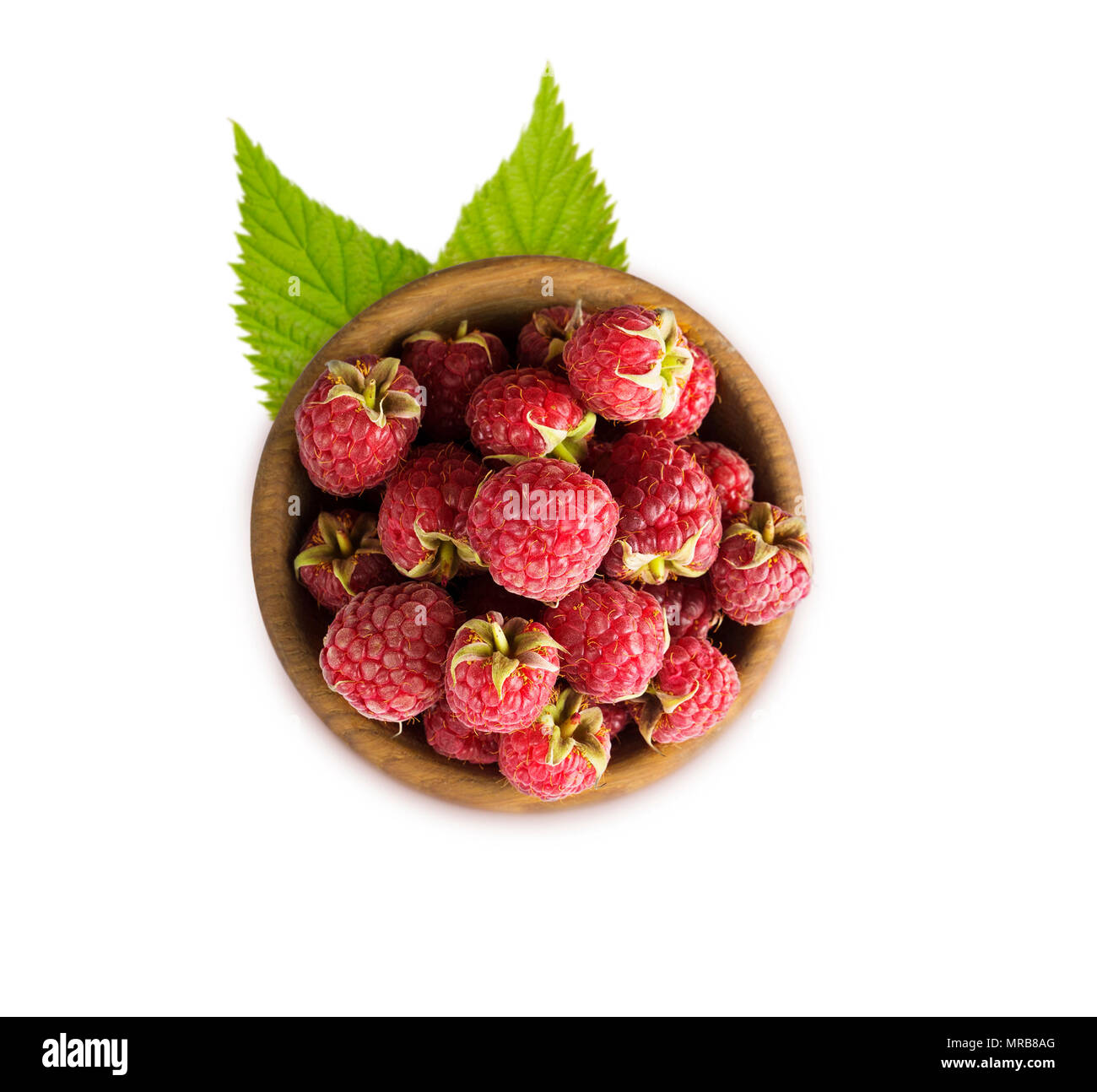 Raspberries with leaves in a wooden bowl isolated on white background ...