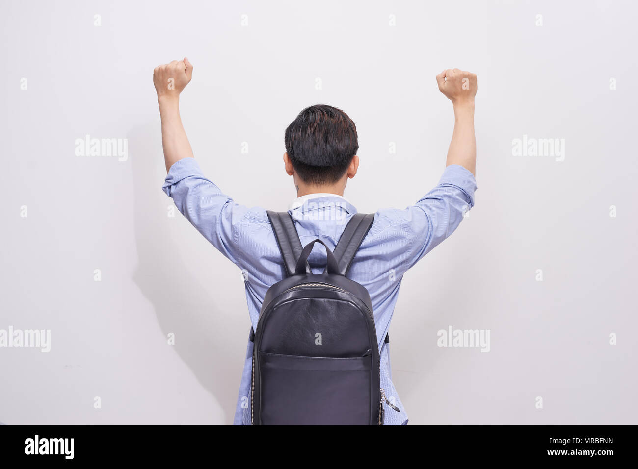 Back view of man with backpack posing with hands up on white background ...