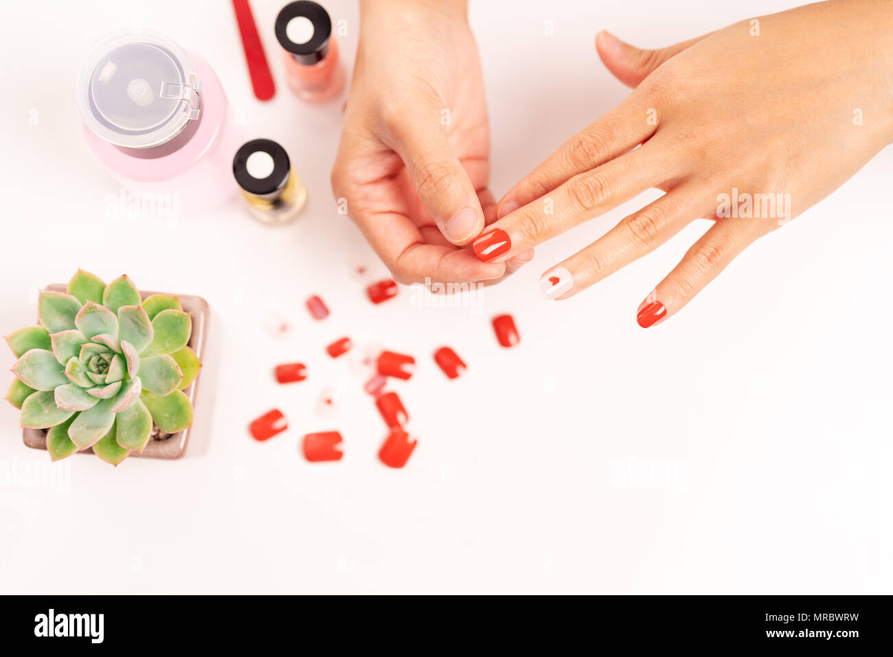 women manicure and attaches a nail shape during the procedure of nail ...