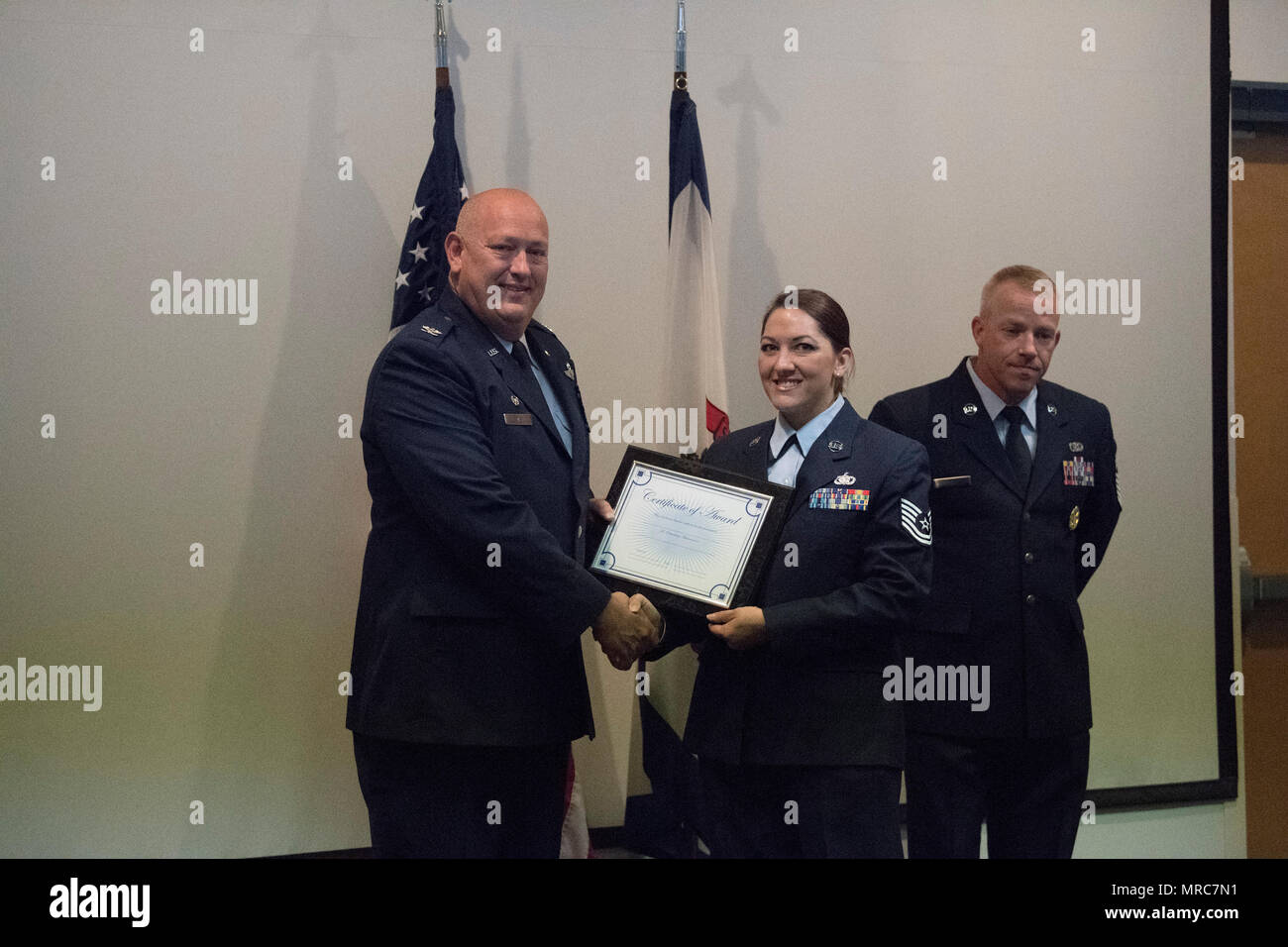 Tech. Sgt. Victoria Grogan shakes the hand of Col. Johnny Ryan, 130th ...