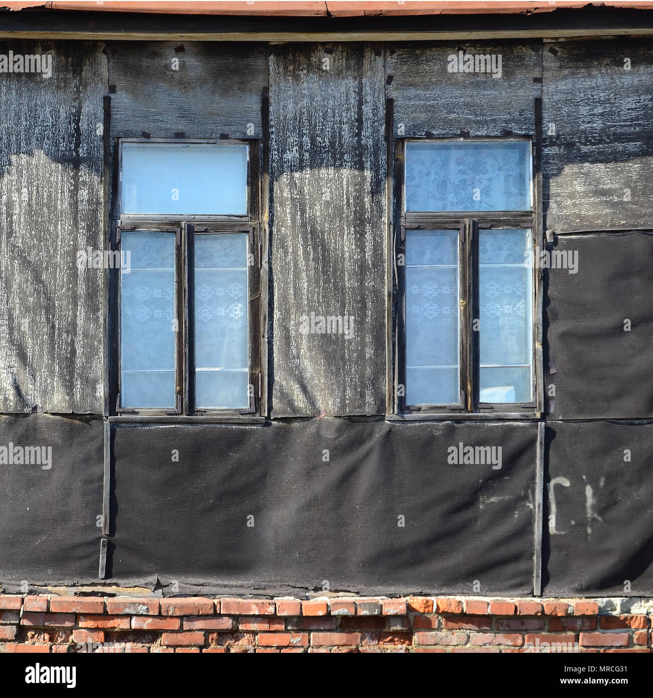 The texture of a brick wall with a few windows. Glazed windows in the ...