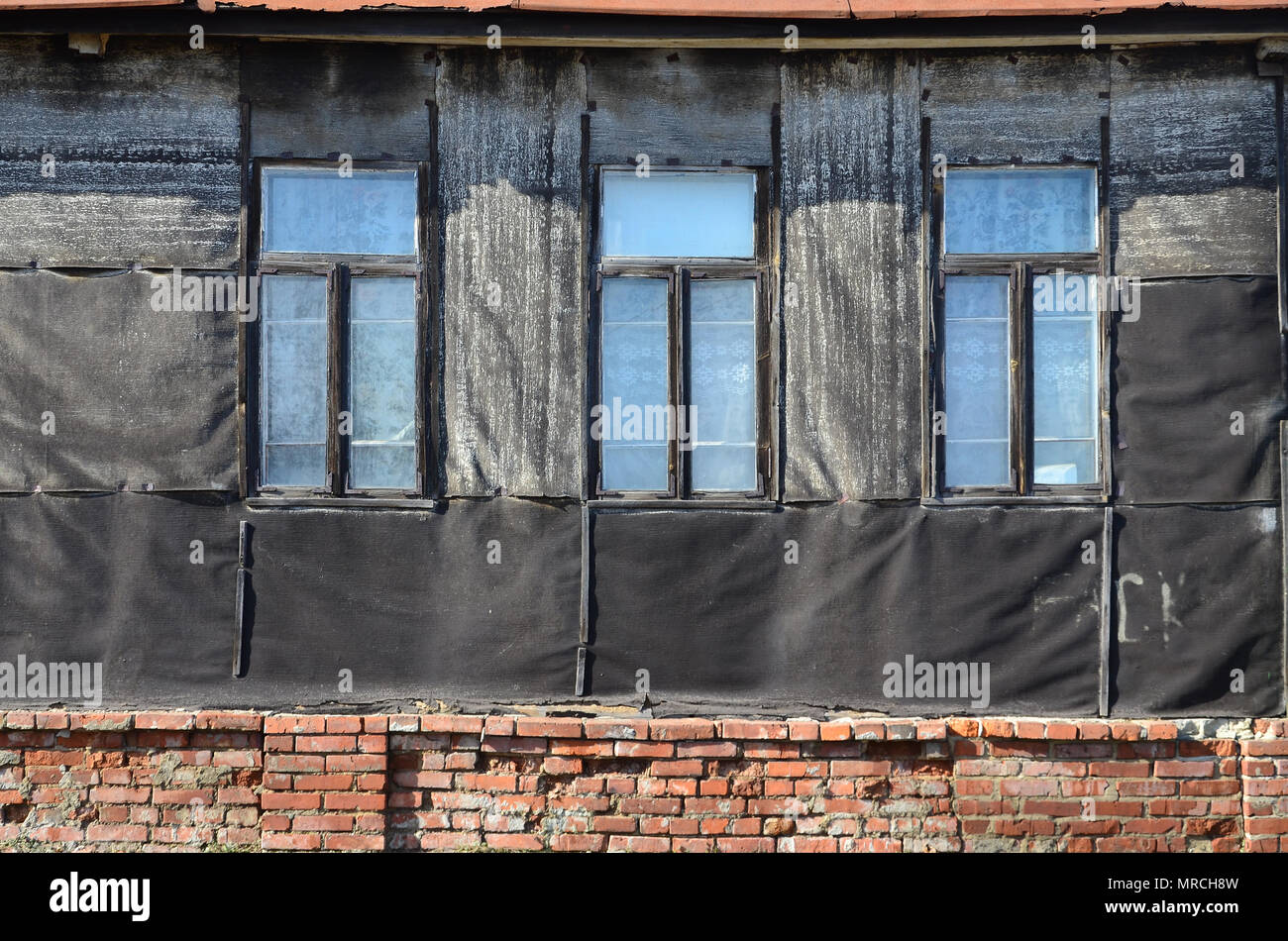 The texture of a brick wall with a few windows. Glazed windows in the ...