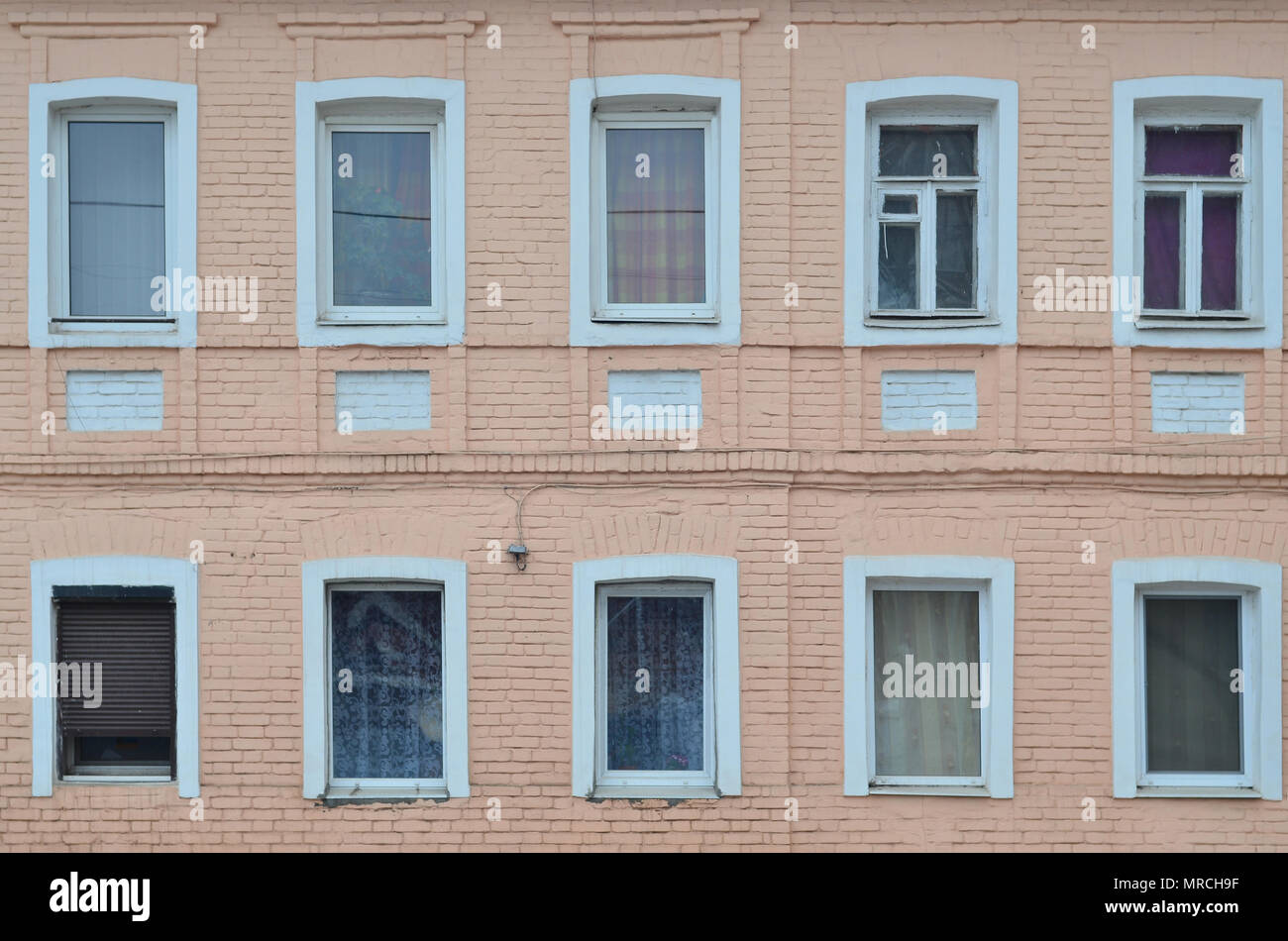 The texture of a brick wall with a few windows. Glazed windows in the ...