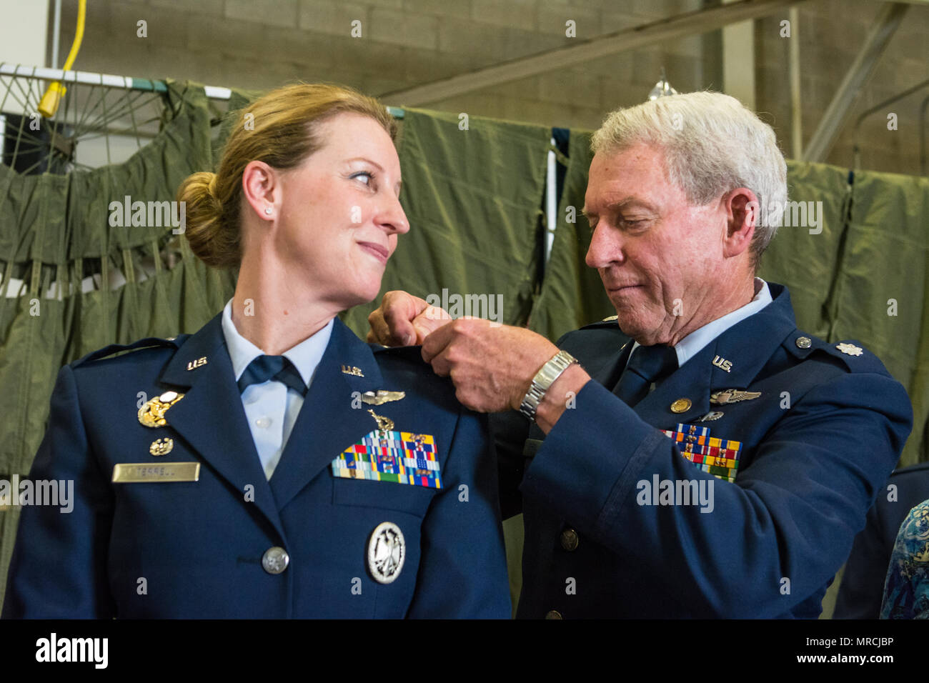 U.S. Air Force retired Lt. Col. Royce Terrell (right) pins the rank of ...