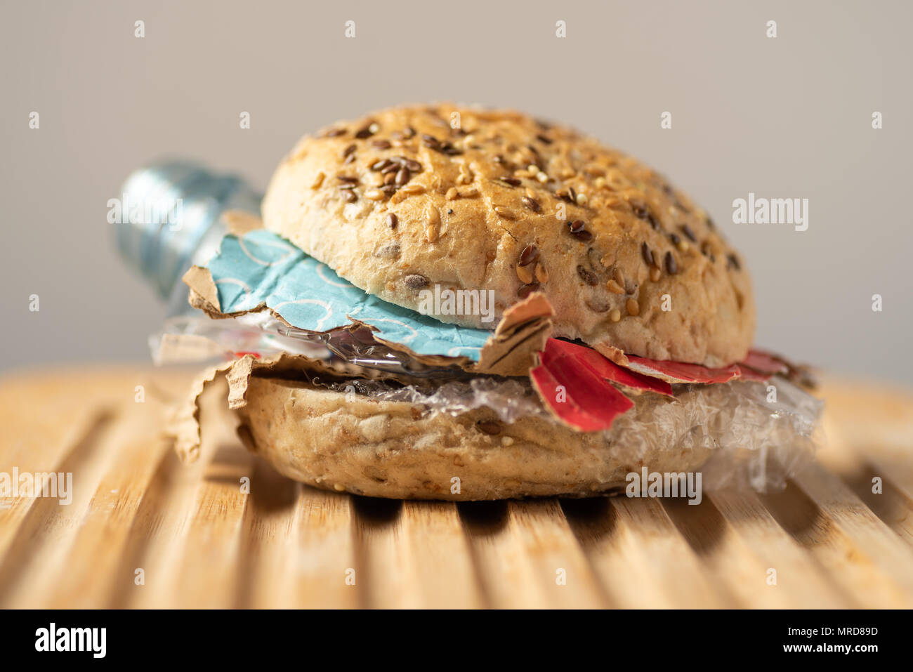 Fresh tasty burger with plastic waste and paper cardboard inside on ...