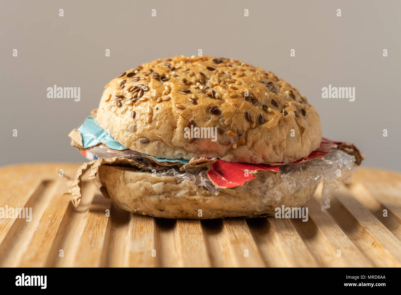 Fresh tasty burger with plastic waste and paper cardboard inside on ...