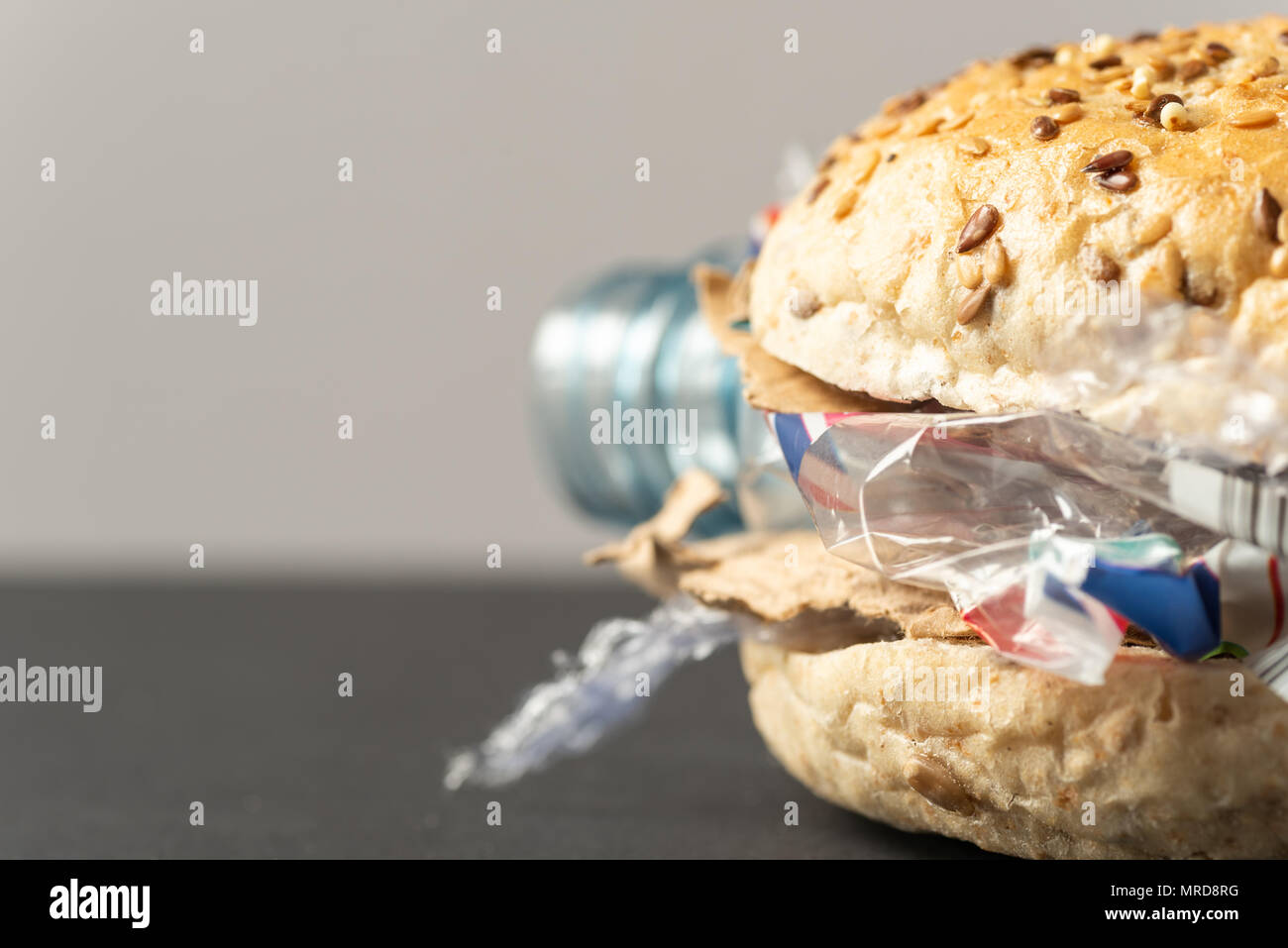 Fresh tasty burger with plastic waste and paper cardboard inside on ...