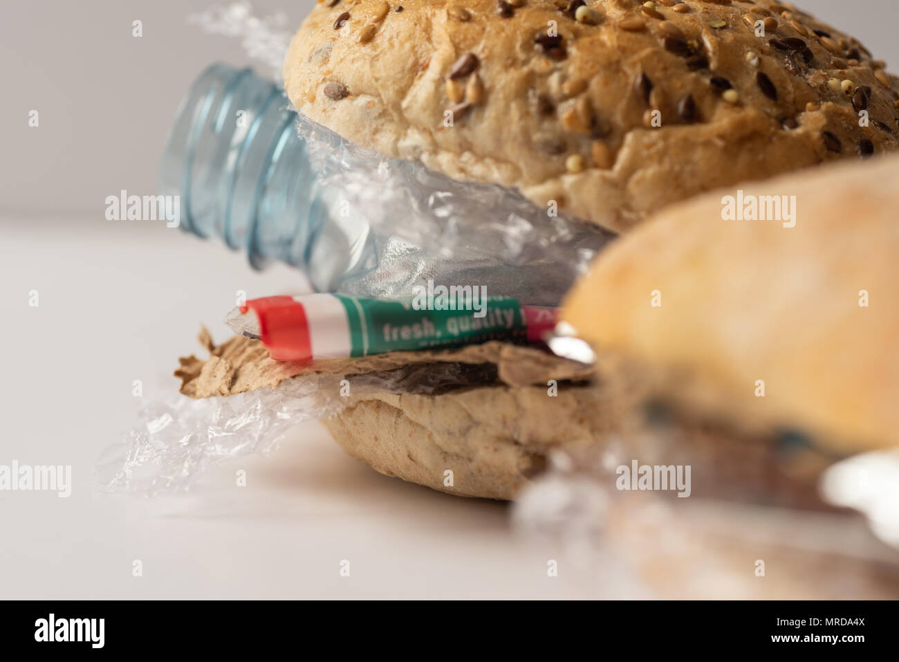 Fresh tasty burger with plastic waste and paper cardboard inside on ...