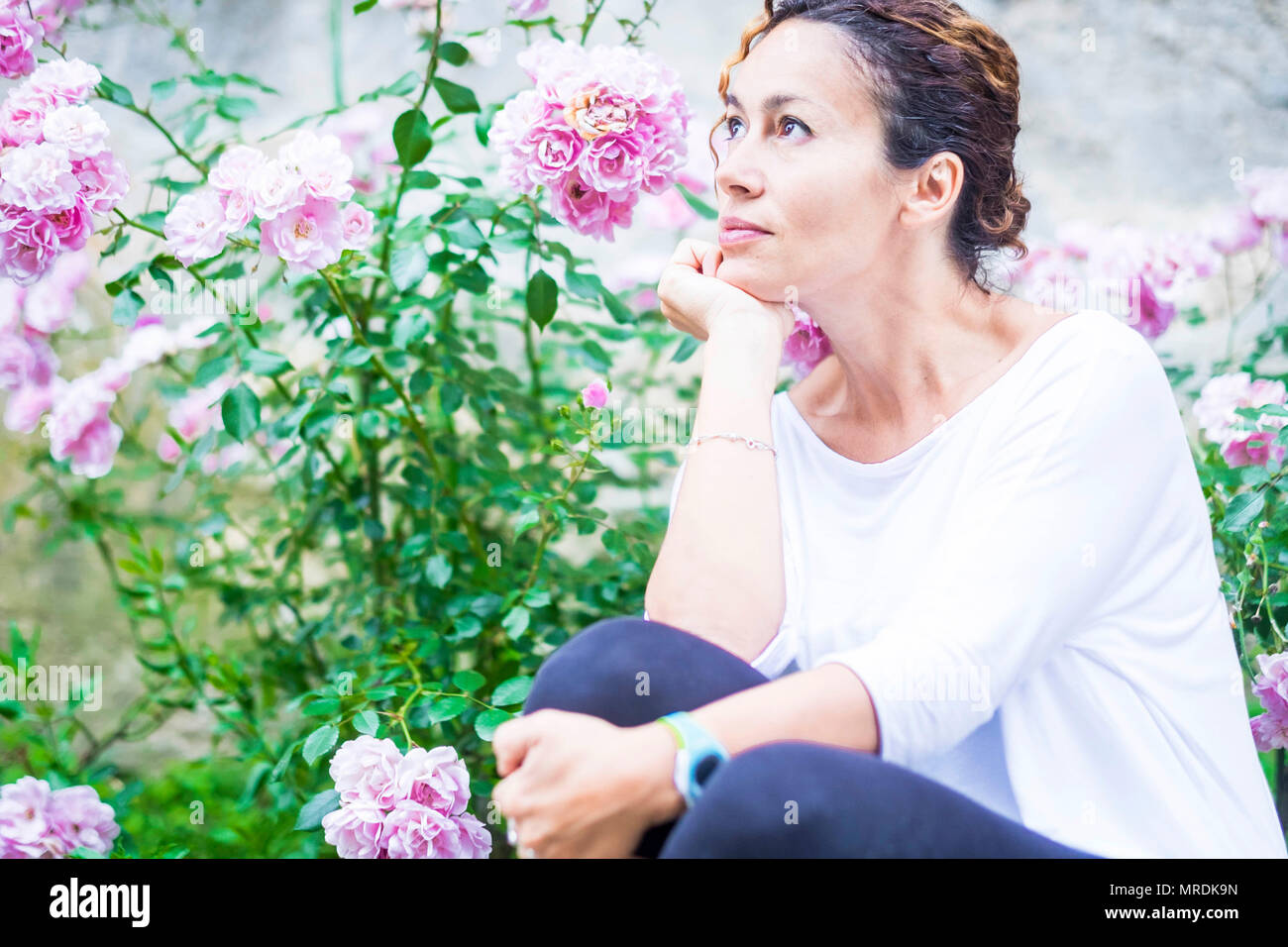 Beautiful wooman 40 years old look at her side thinking happy. Roses ...