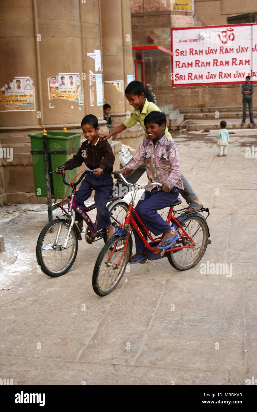 Two Indian Kids on Bikes with One Balancing in the Middle, Varanasi ...