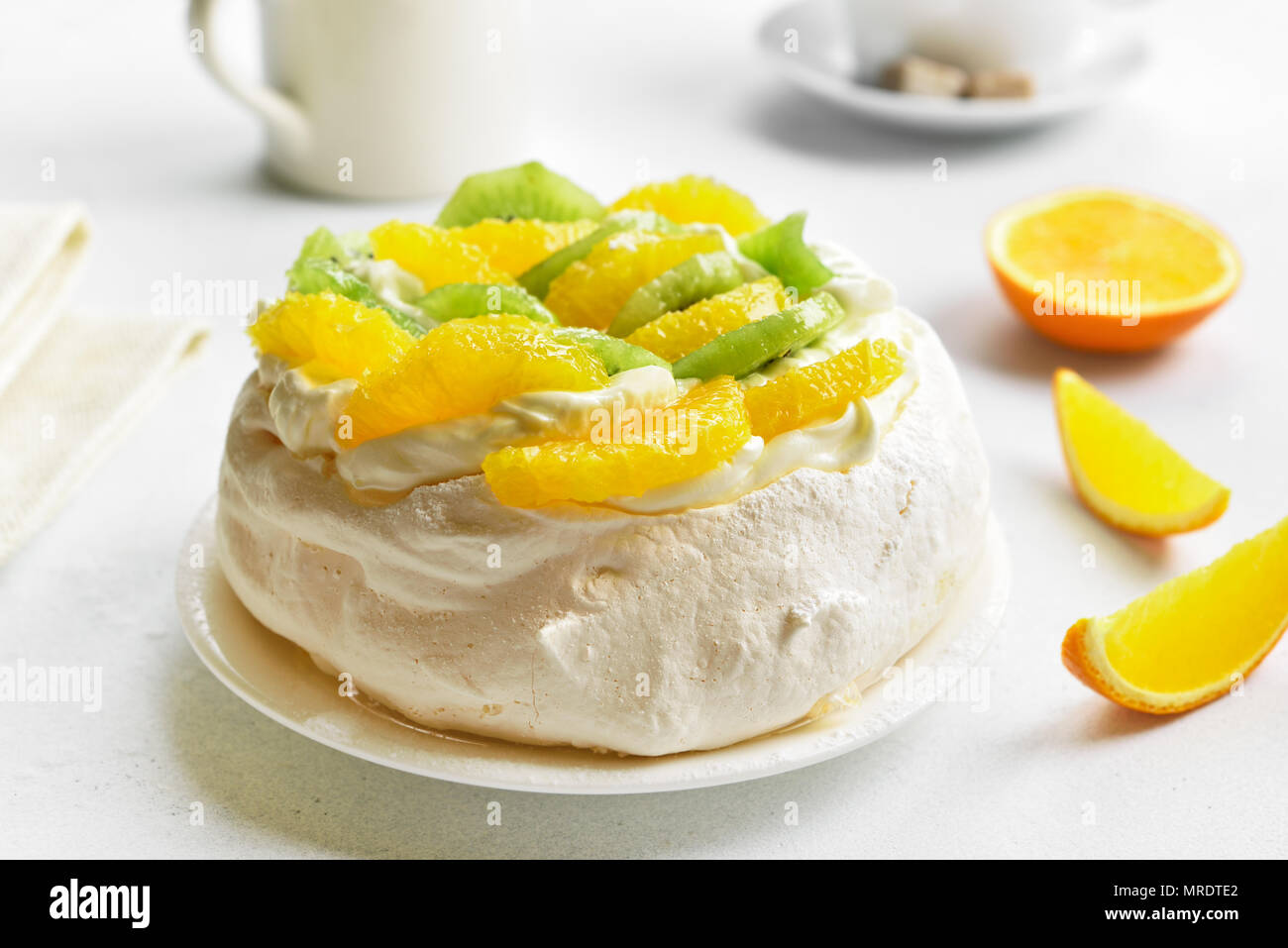 Dessert pavlova meringue cake with kiwi, orange slices and whipped ...