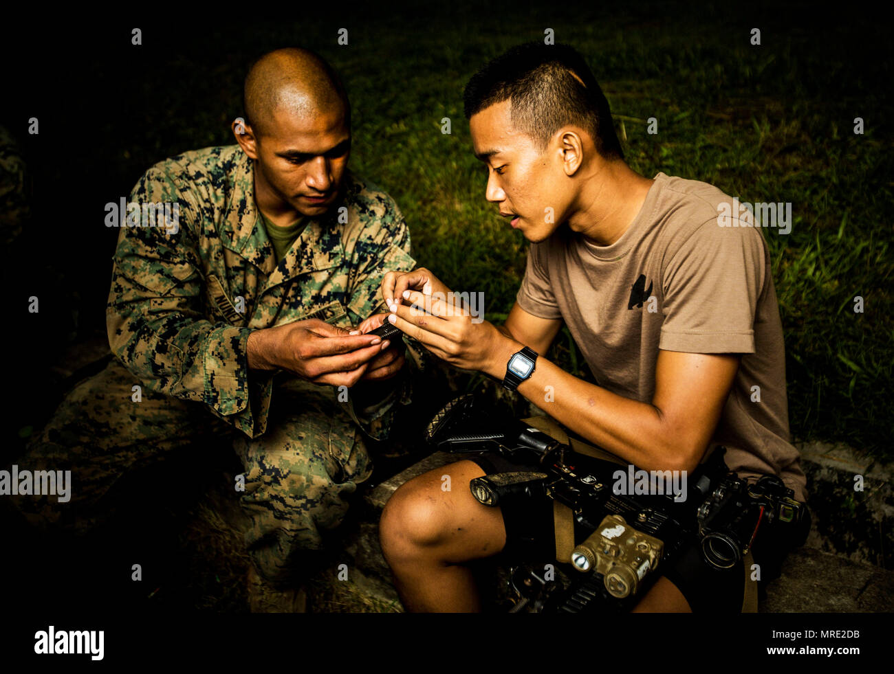 Lance Cpl. Moses Nunez plays a game on his mobile phone with a Royal ...