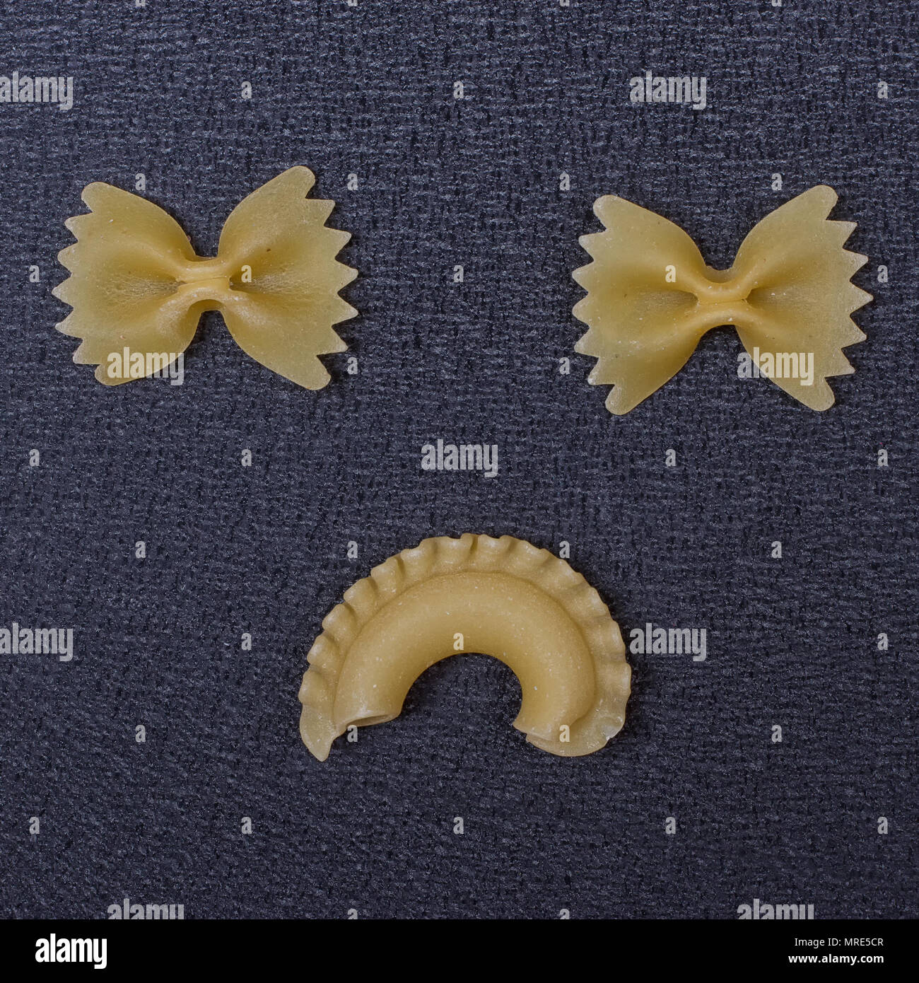 Smiling raw pasta on the black background Stock Photo - Alamy