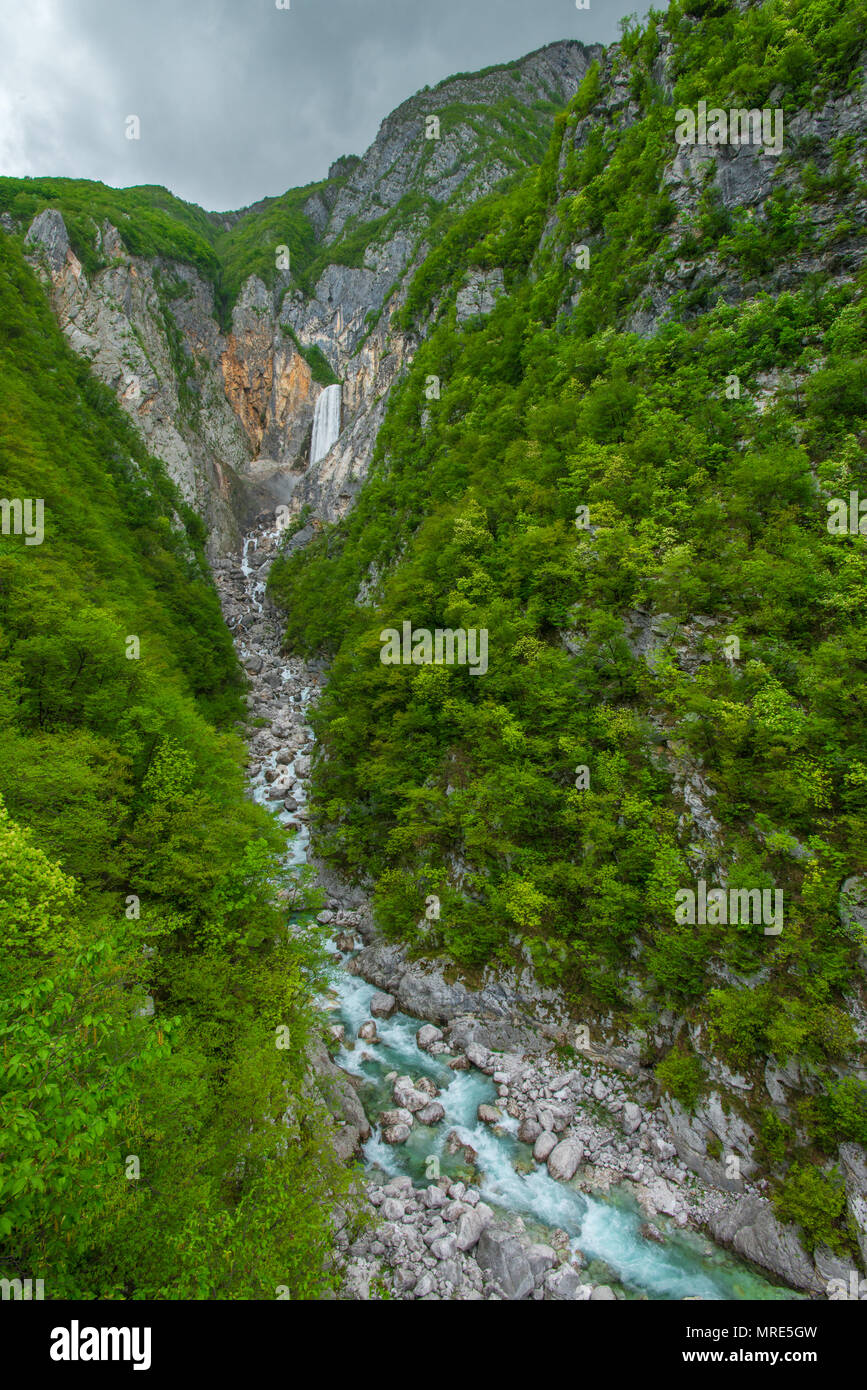 Distant, massive waterfall cascading down steep rocky slopes at the ...