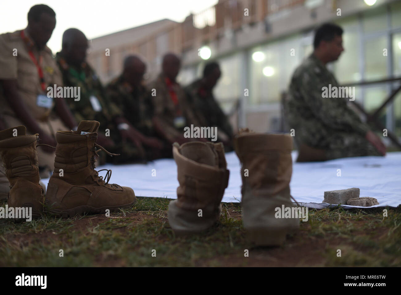 Military boots rest near a sheet placed on the ground for a prayer ...