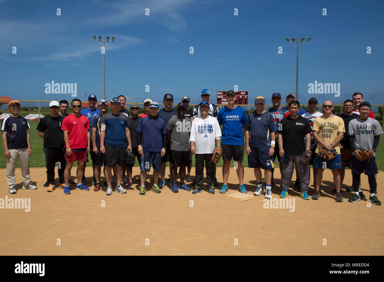 Players pose for a group photo before a friendship softball game and ...