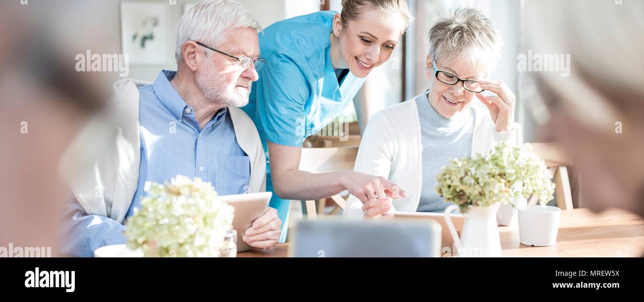 Senior adults using digital tablets in care home Stock Photo - Alamy