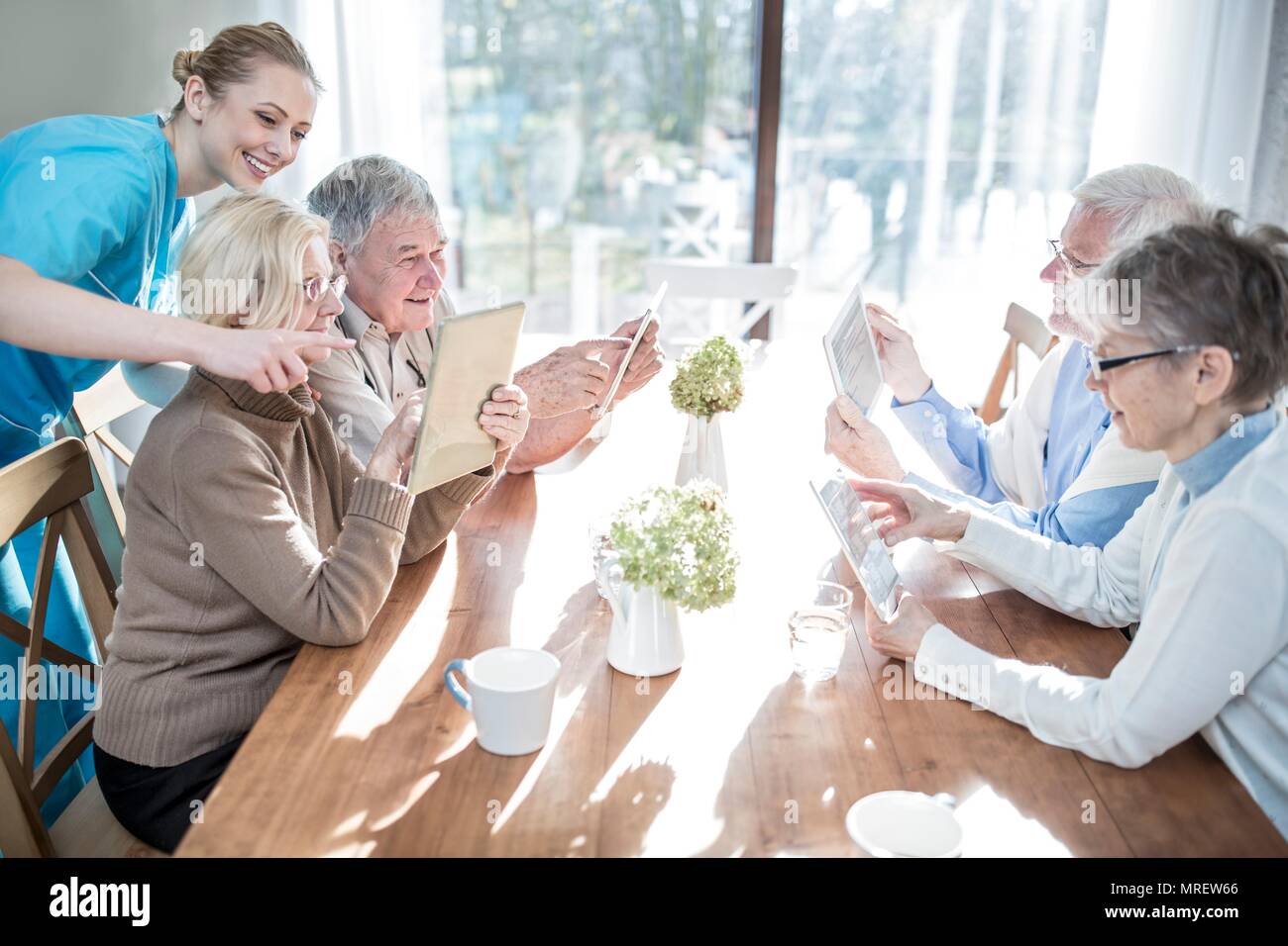 Senior adults using digital tablets in care home Stock Photo - Alamy