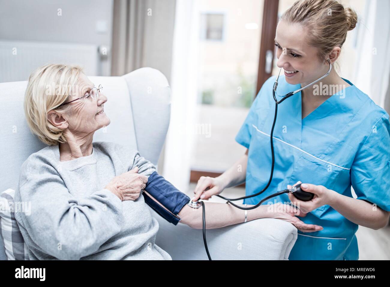 Senior woman having her blood pressure taken by care worker Stock Photo ...