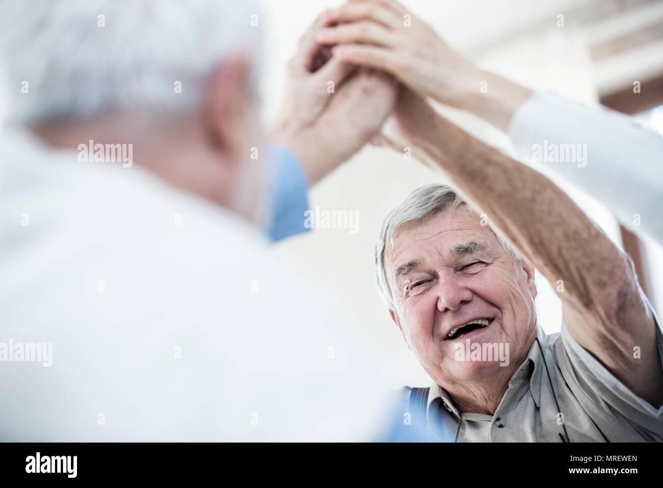 Senior men giving high five Stock Photo - Alamy
