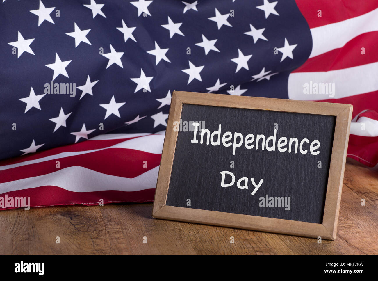 "Independence Day" text written on a chalkboard with the American flag ...