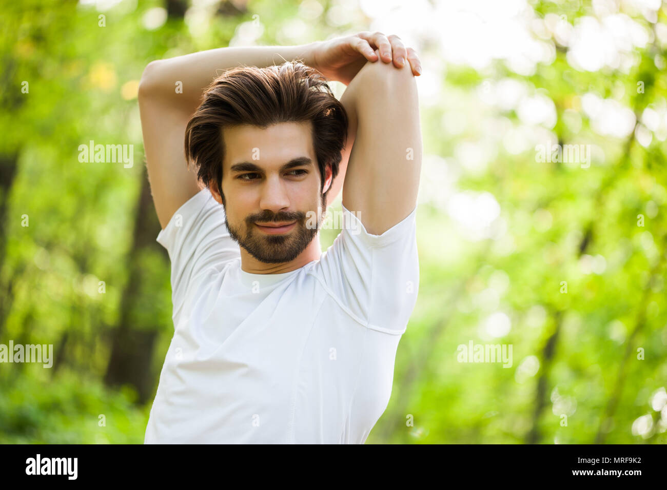 Young man is exercising in park. He is stretching his body Stock Photo ...