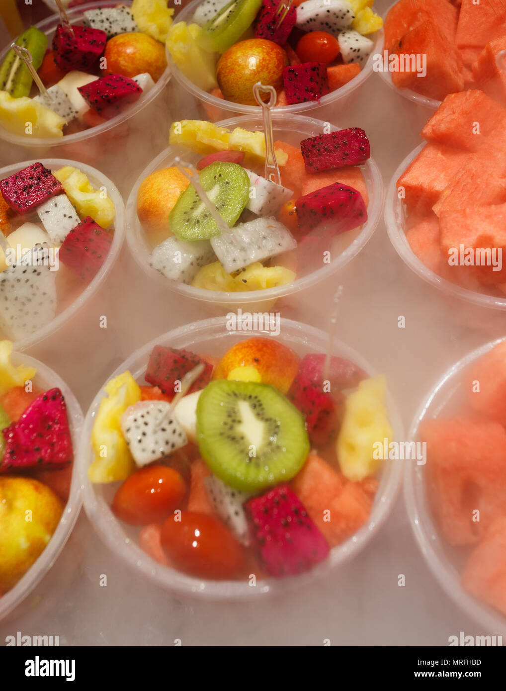 Cut pieces of all kinds of fresh fruits and sell them in small plastic ...