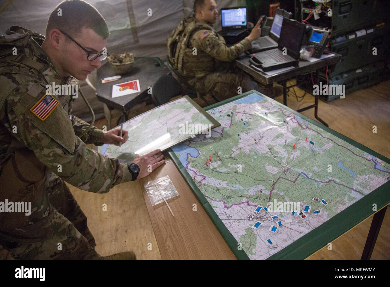 A Battle Group Poland U.S. Soldier prepares maps in the tactical ...