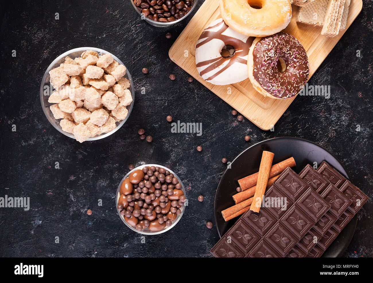 Different types of deserts on a black wooden table in studio photo ...