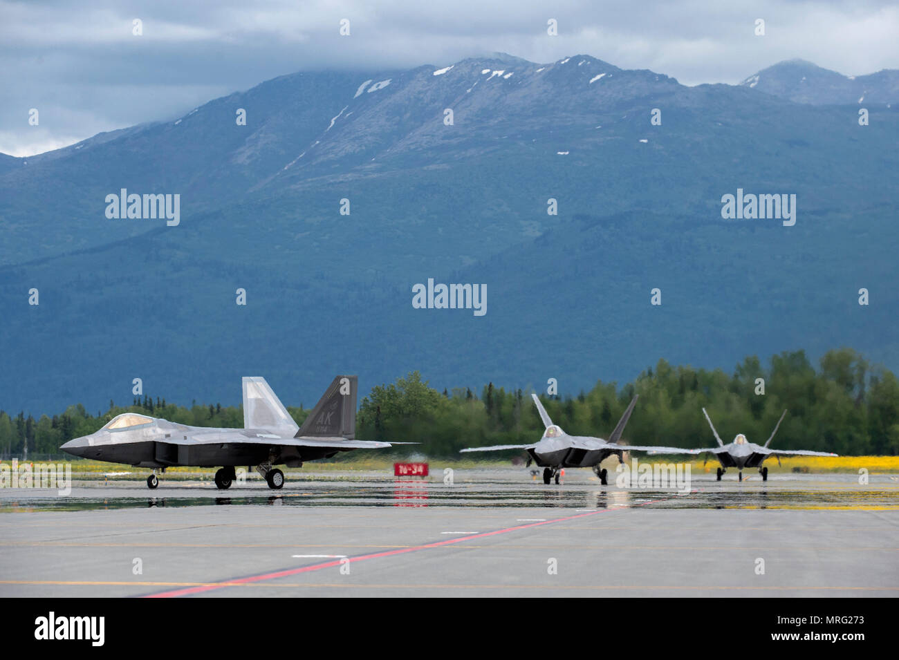 Three U.S. Air Force F-22 Raptors, assigned to the 3rd Wing, taxi ...