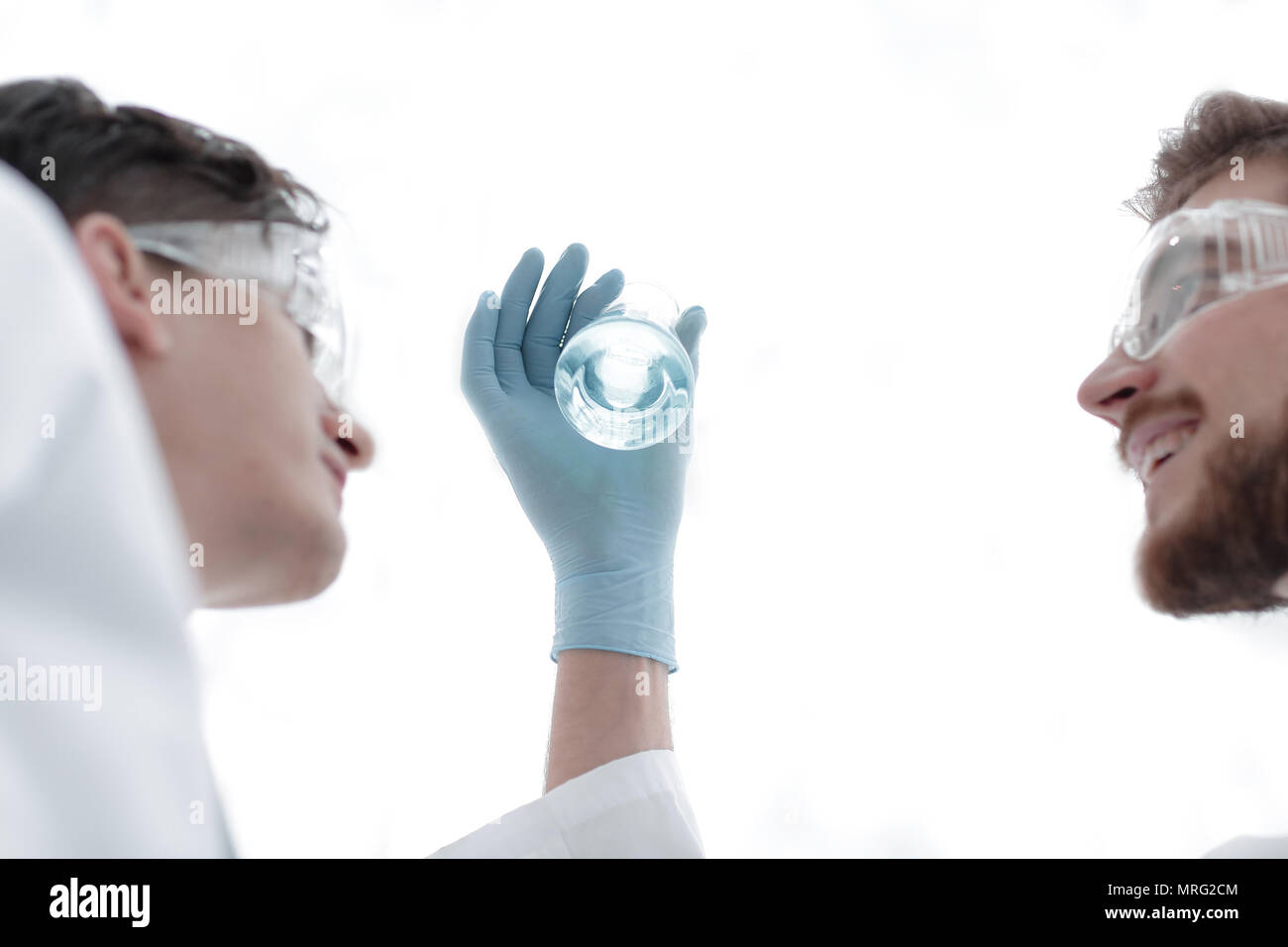 closeup. two scientists examining liquid in the beaker Stock Photo - Alamy