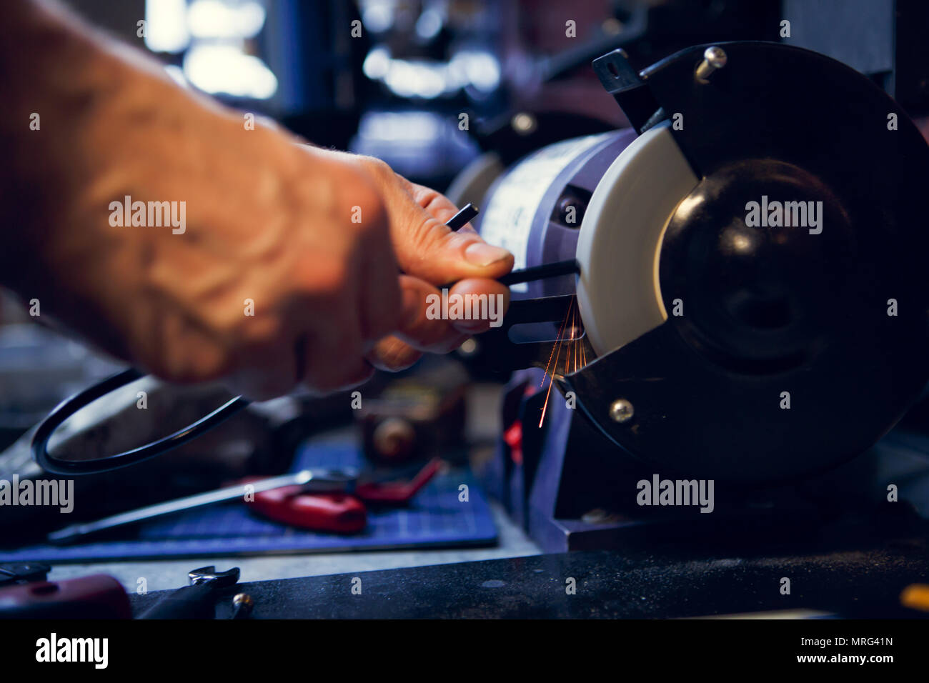 Image of man sharpening tool Stock Photo - Alamy