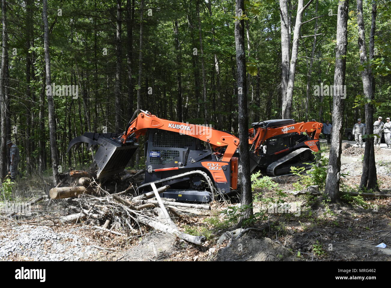 Skid loaders driven by U.S. Air Force Staff Sgt. Adam Palmer (left) and ...