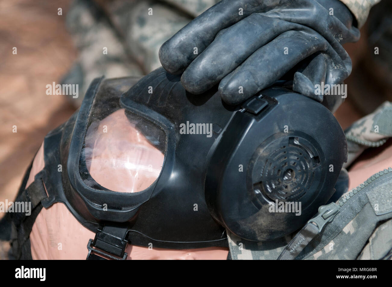 A Warrior places a gas mask on a mock patient during a nuclear ...